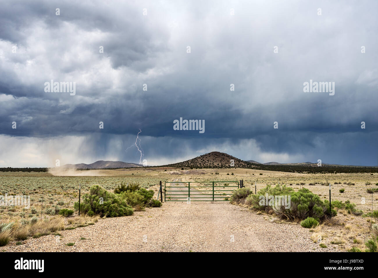 Desert landscape with a dust devil and thunderstorm lightning strike ...