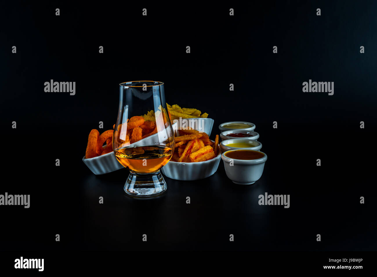 set of snacks with different dips and a single malt in a glass, crunchy ...