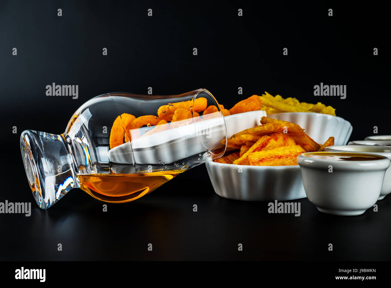set of snacks with different dips and a single malt in a glass, crunchy ...