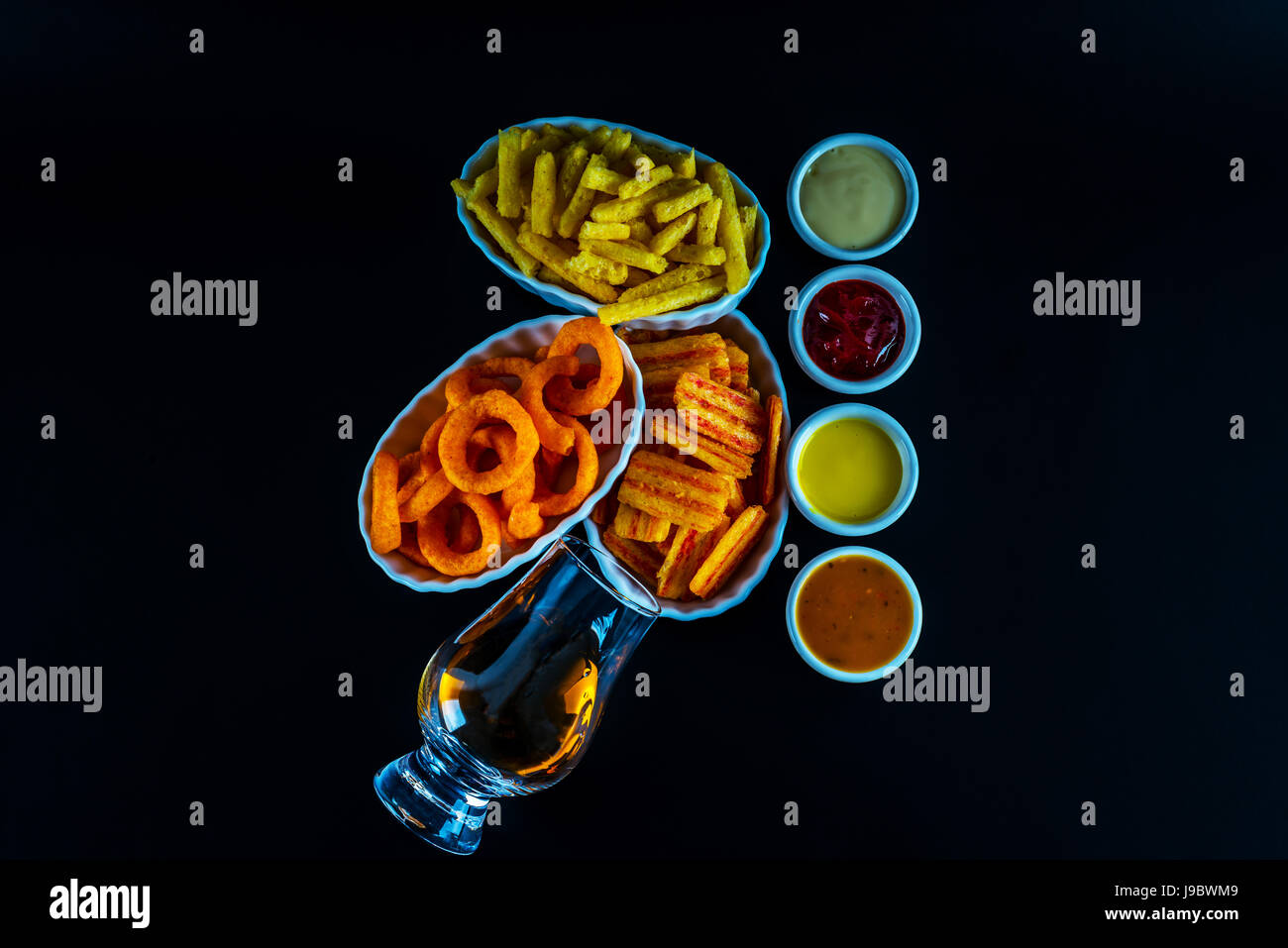 set of snacks with different dips and a single malt in a glass, crunchy ...