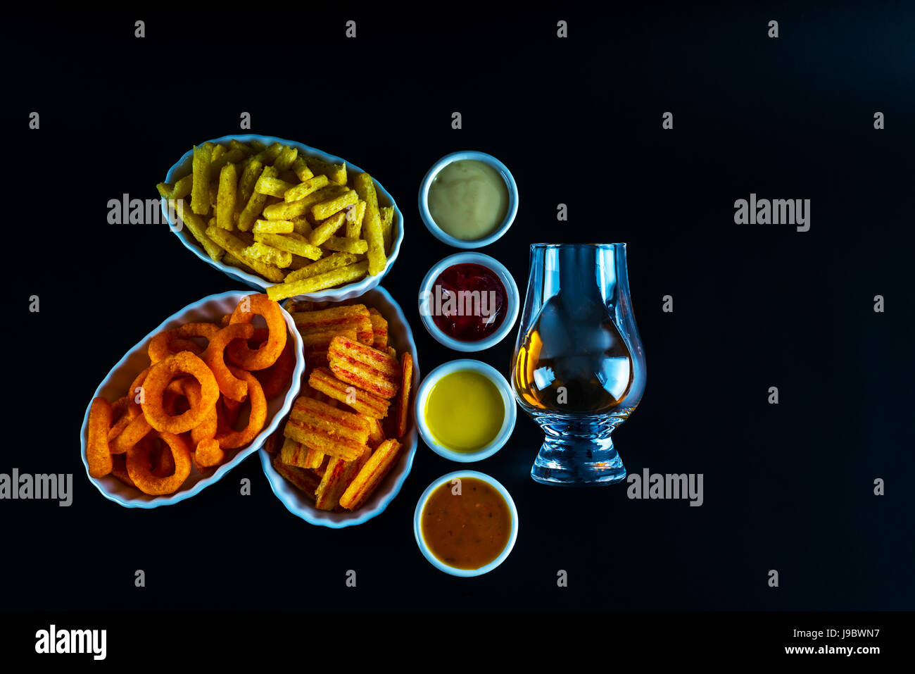 set of snacks with different dips and a single malt in a glass, crunchy ...