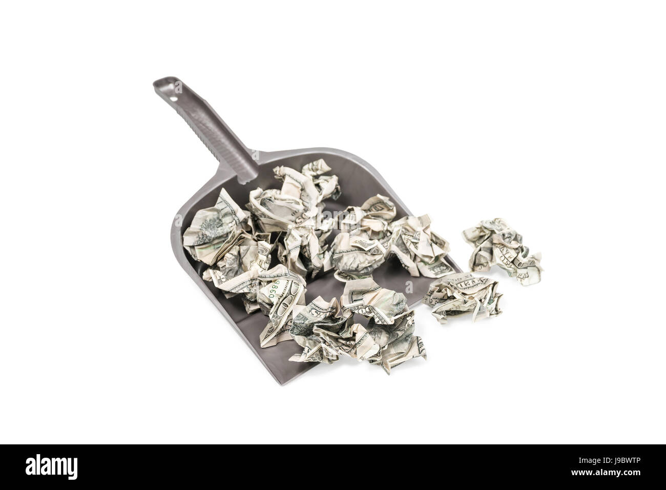 Pile of crumpled money in a garbage shovel isolated on white background ...