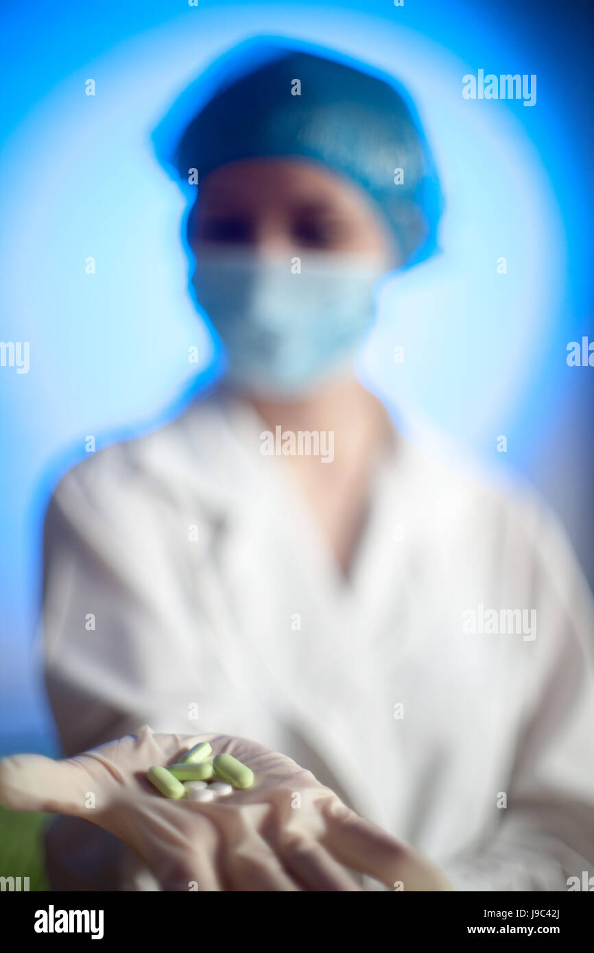A nurse in a hospital with medication tablets in his hand for the sick ...