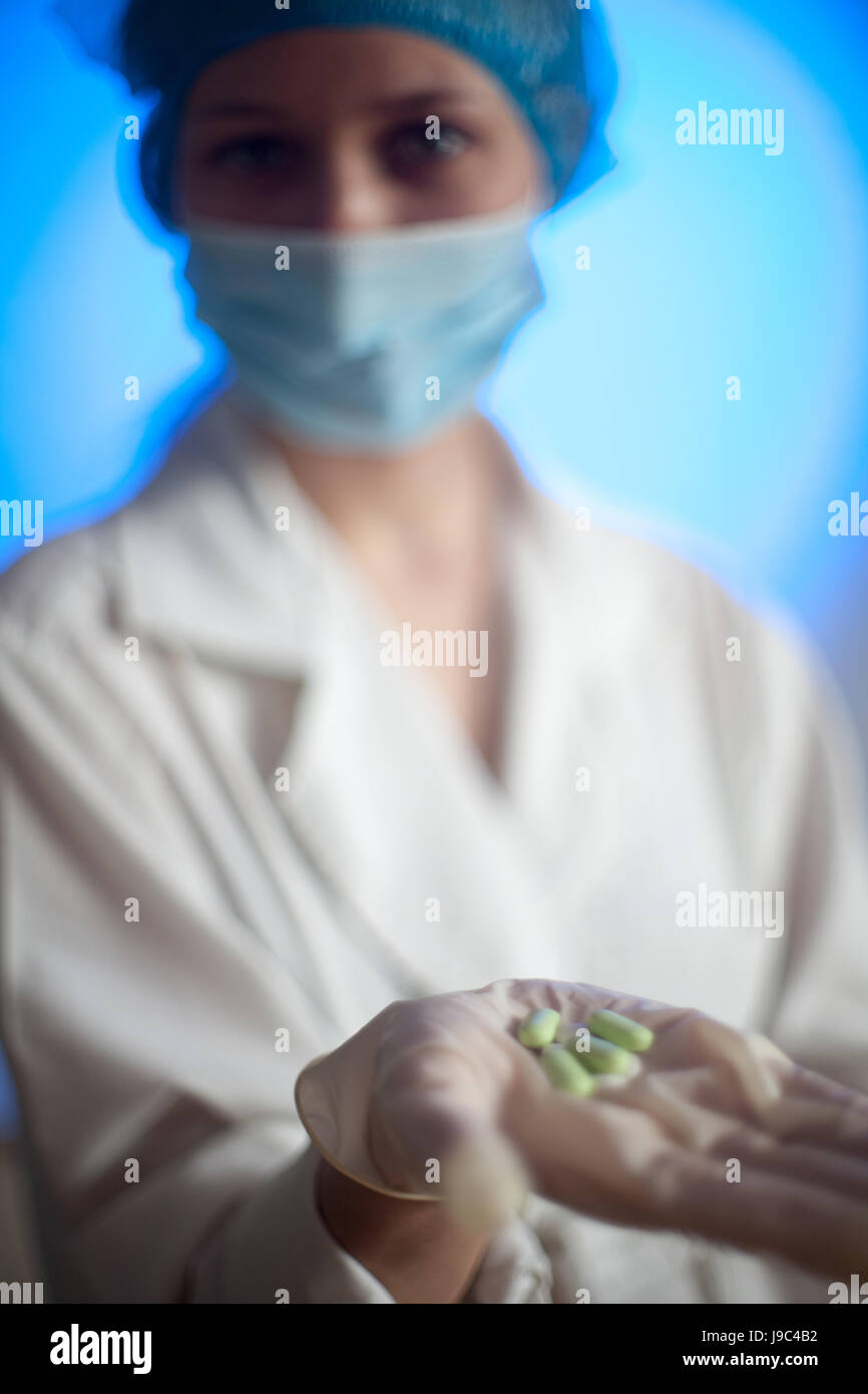 A nurse in a hospital with medication tablets in his hand for the sick ...