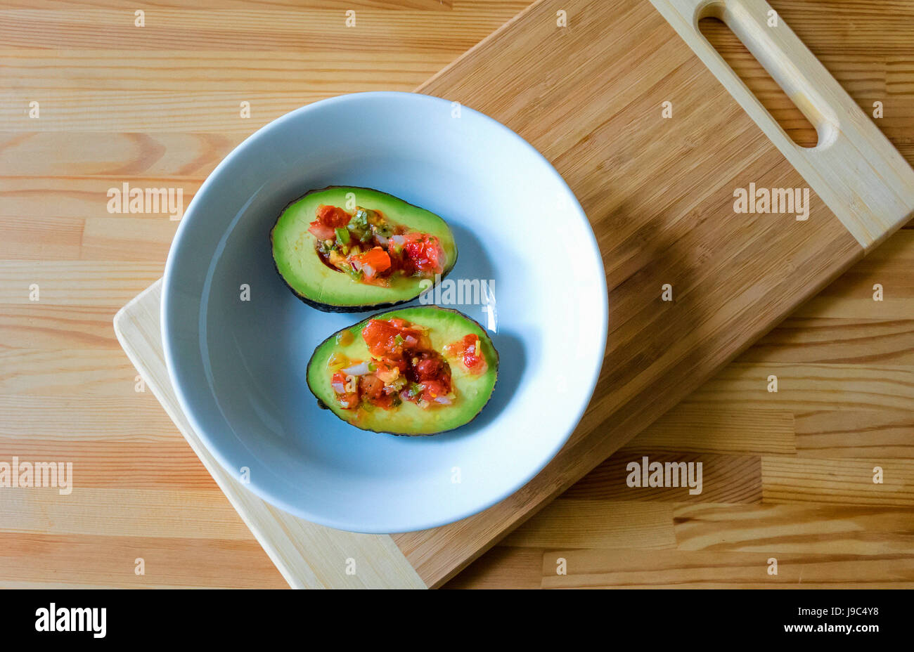 Avocado and salsa fresca in a small white bowl Stock Photo - Alamy