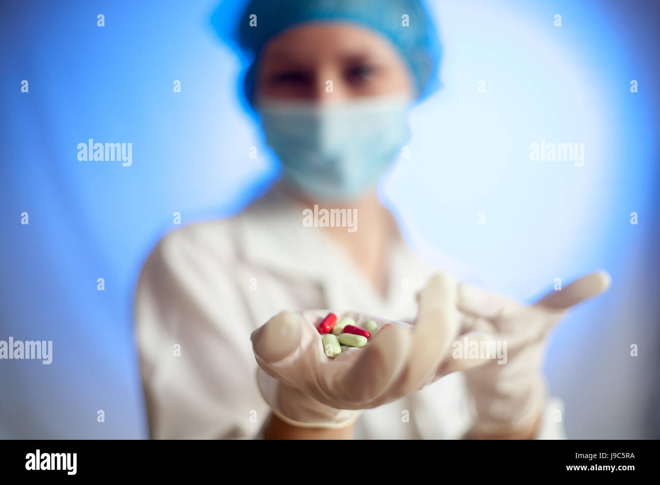 A nurse in a hospital with medication tablets in his hand for the sick ...