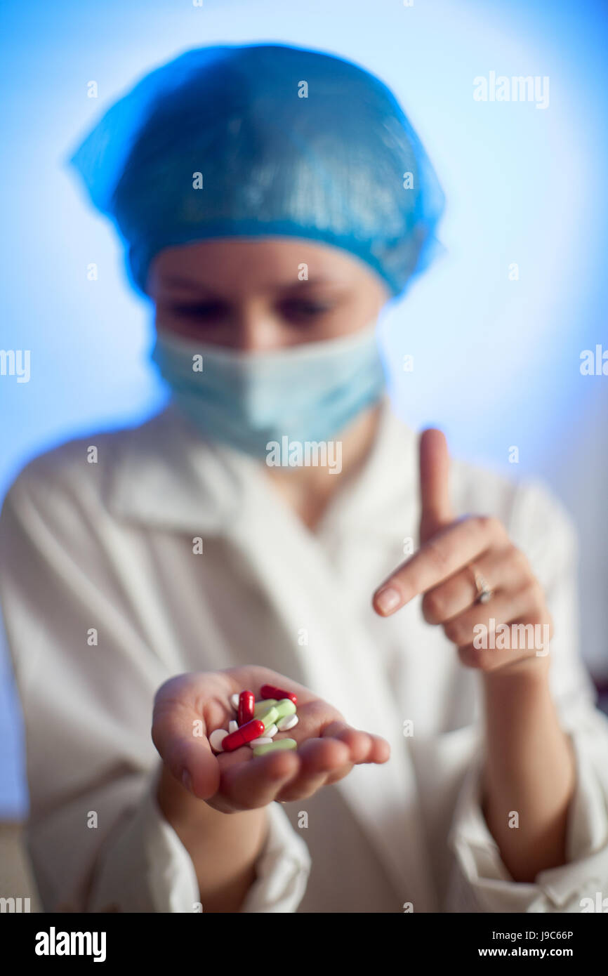 A nurse in a hospital with medication tablets in his hand for the sick ...