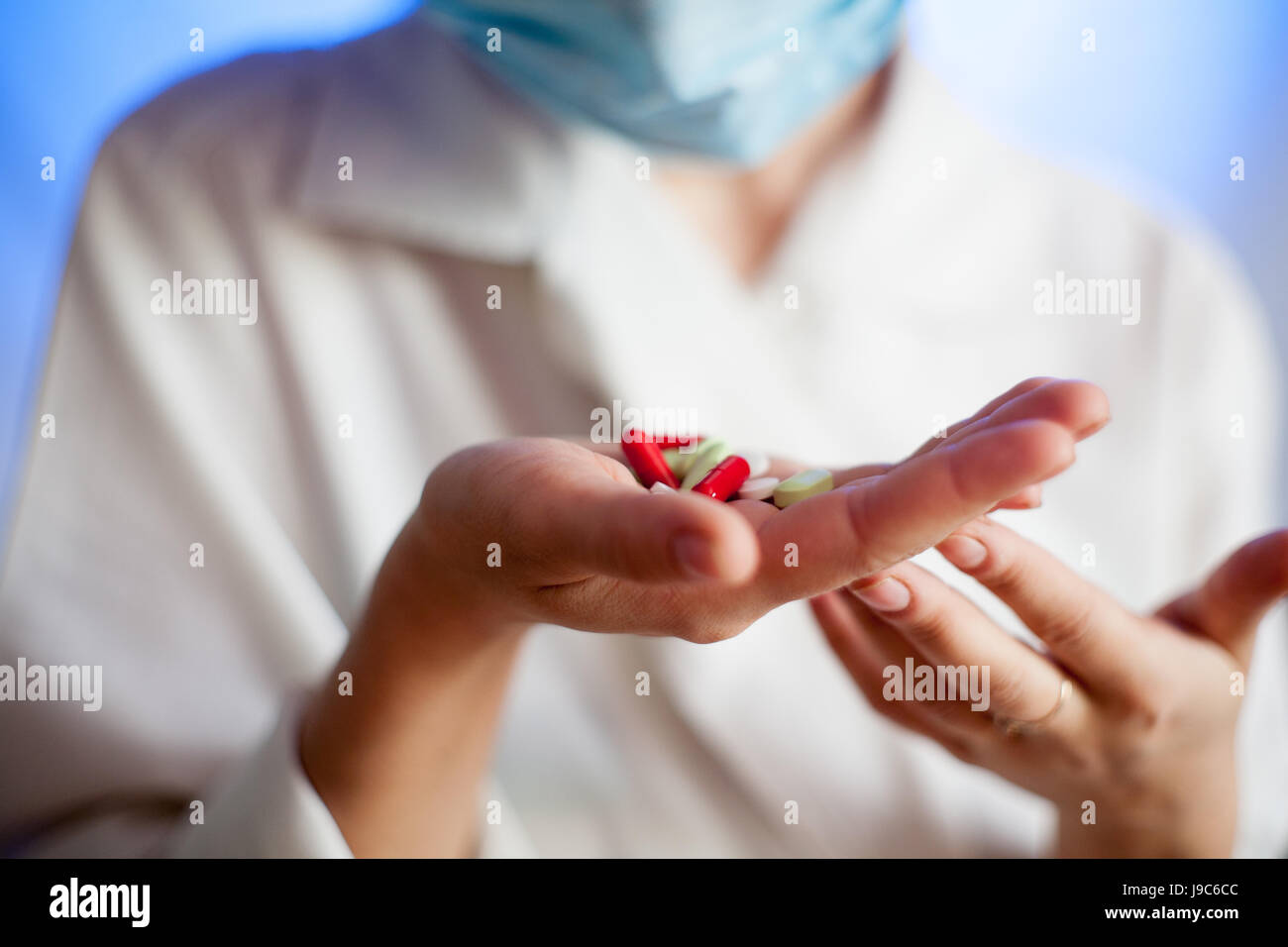 A nurse in a hospital with medication tablets in his hand for the sick ...