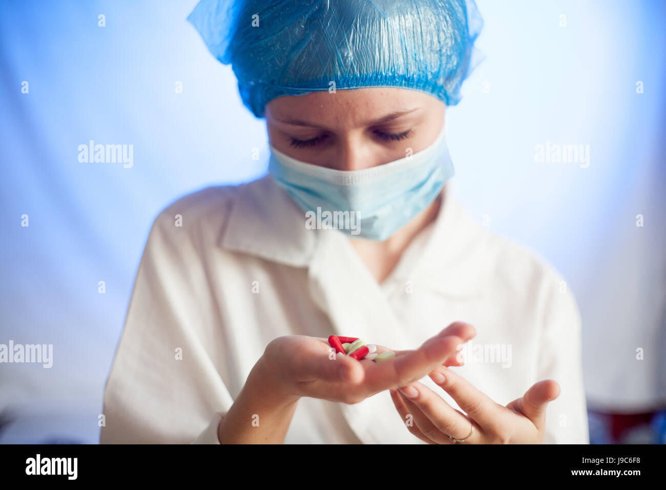 A nurse in a hospital with medication tablets in his hand for the sick ...