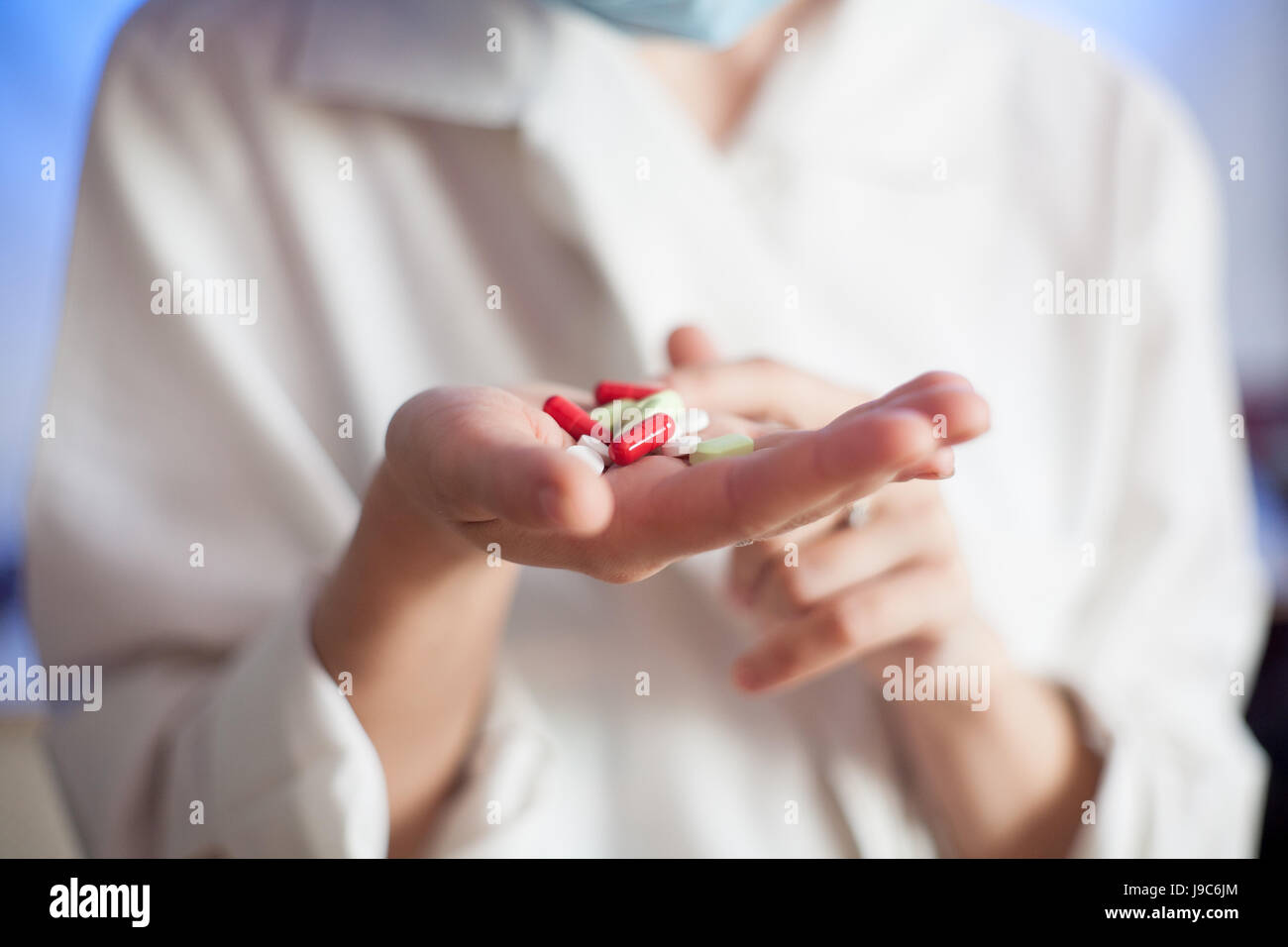 A nurse in a hospital with medication tablets in his hand for the sick ...