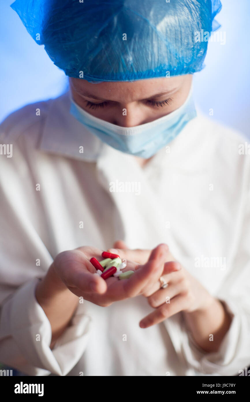A nurse in a hospital with medication tablets in his hand for the sick ...