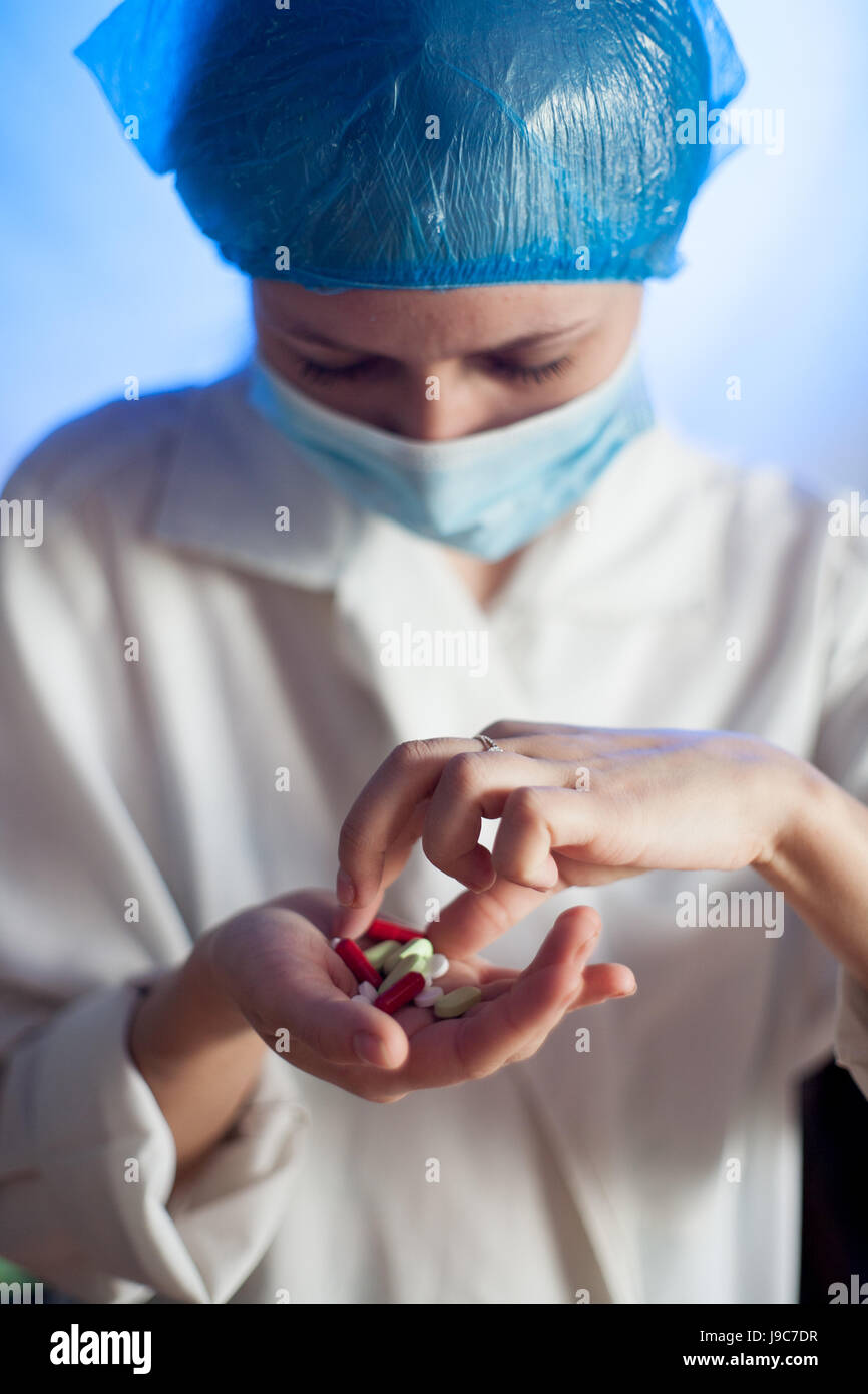 A nurse in a hospital with medication tablets in his hand for the sick ...