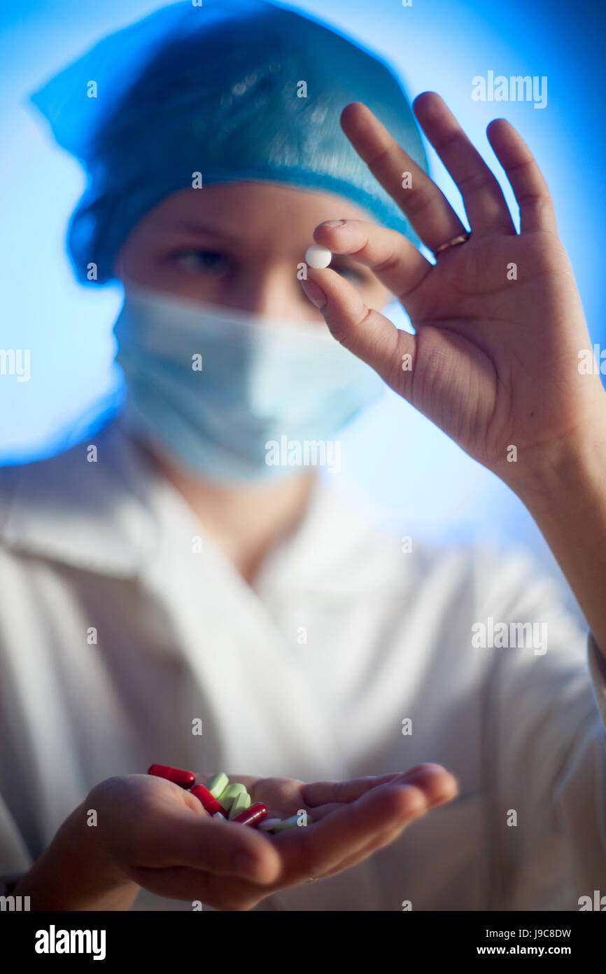 A nurse in a hospital with medication tablets in his hand for the sick ...