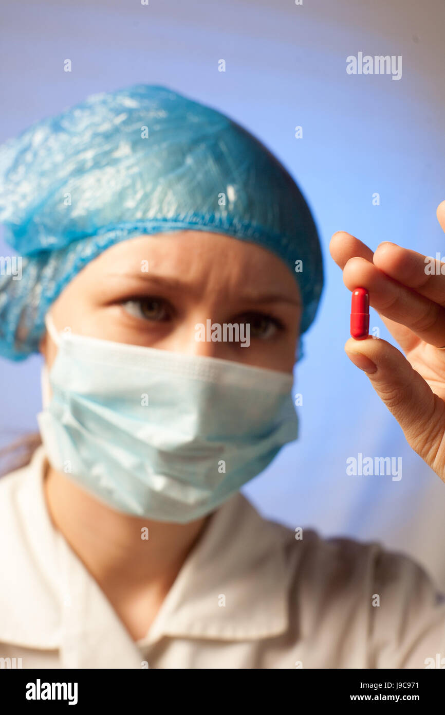 A nurse in a hospital with medication tablets in his hand for the sick ...