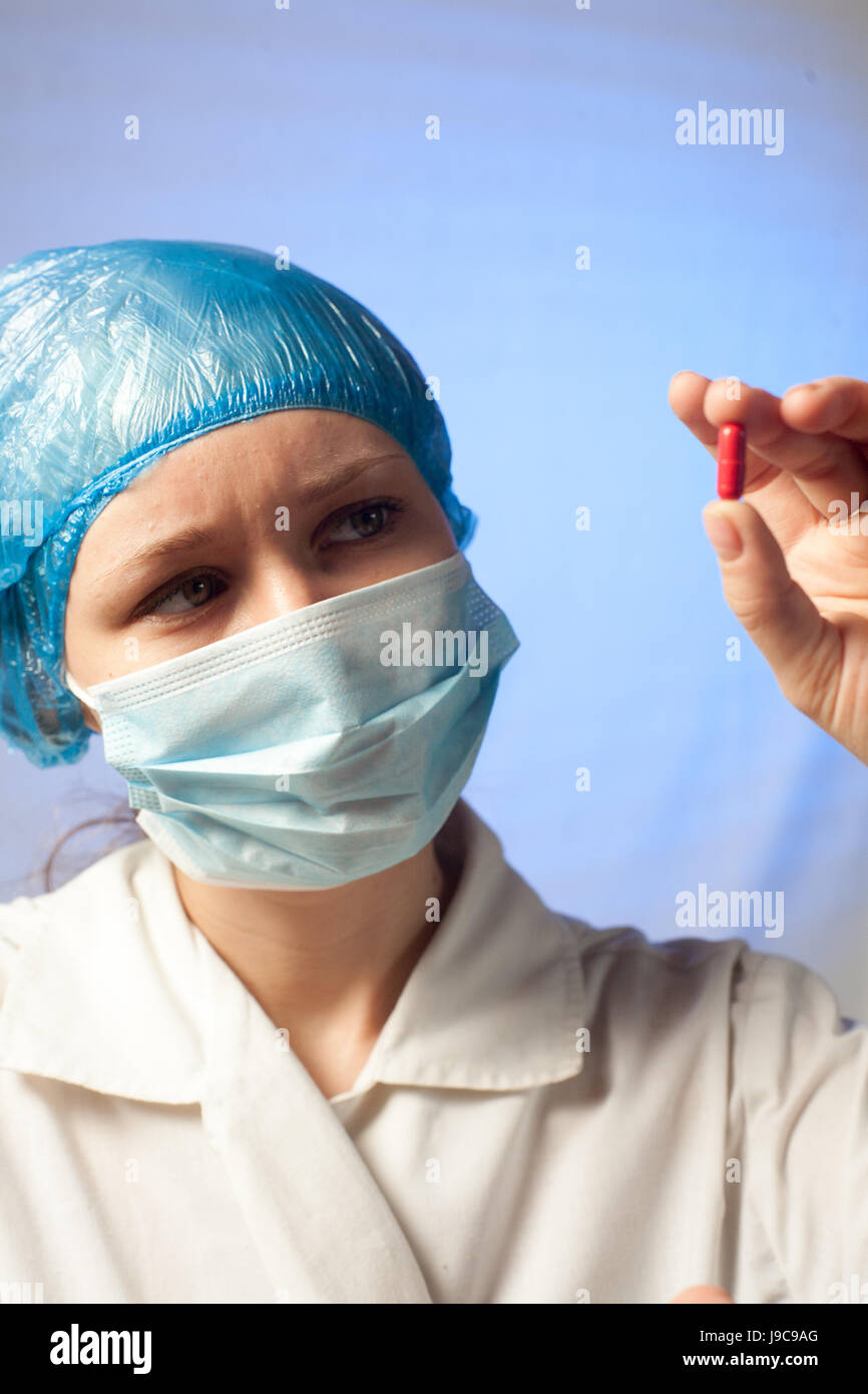 A nurse in a hospital with medication tablets in his hand for the sick ...