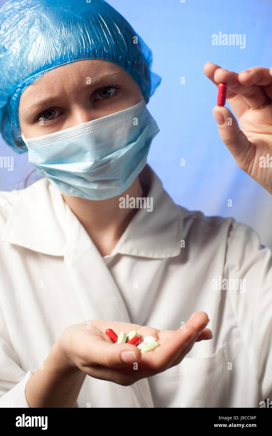 A nurse in a hospital with medication tablets in his hand for the sick ...