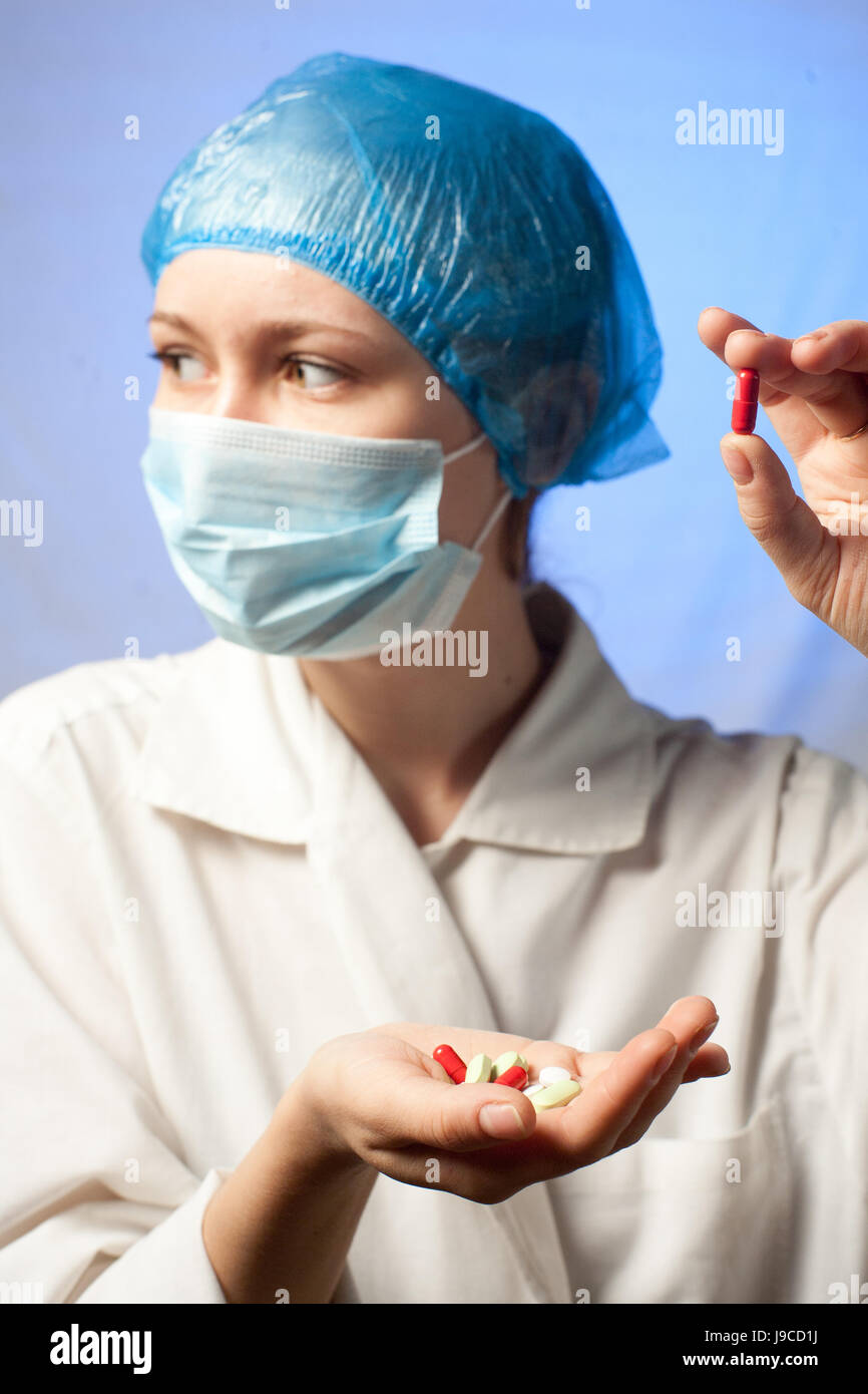 A nurse in a hospital with medication tablets in his hand for the sick ...