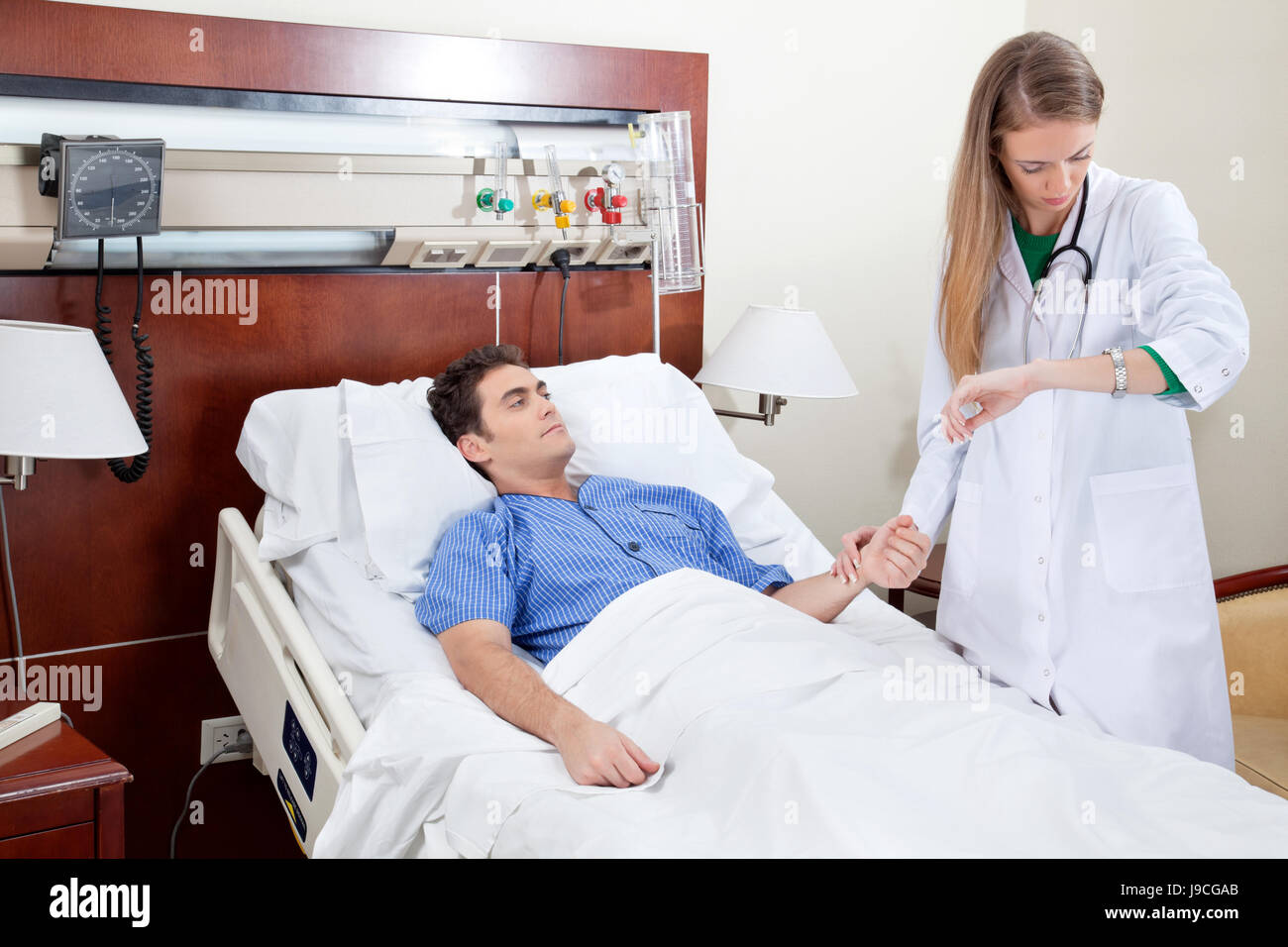 Female physician checking her watch hi-res stock photography and images ...
