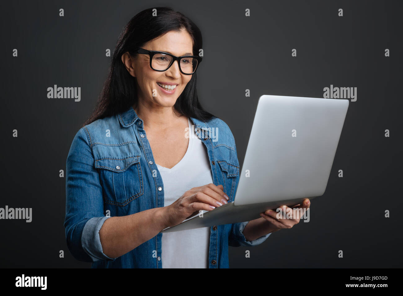 Convenient communication. Smart focused stunning woman using her laptop ...