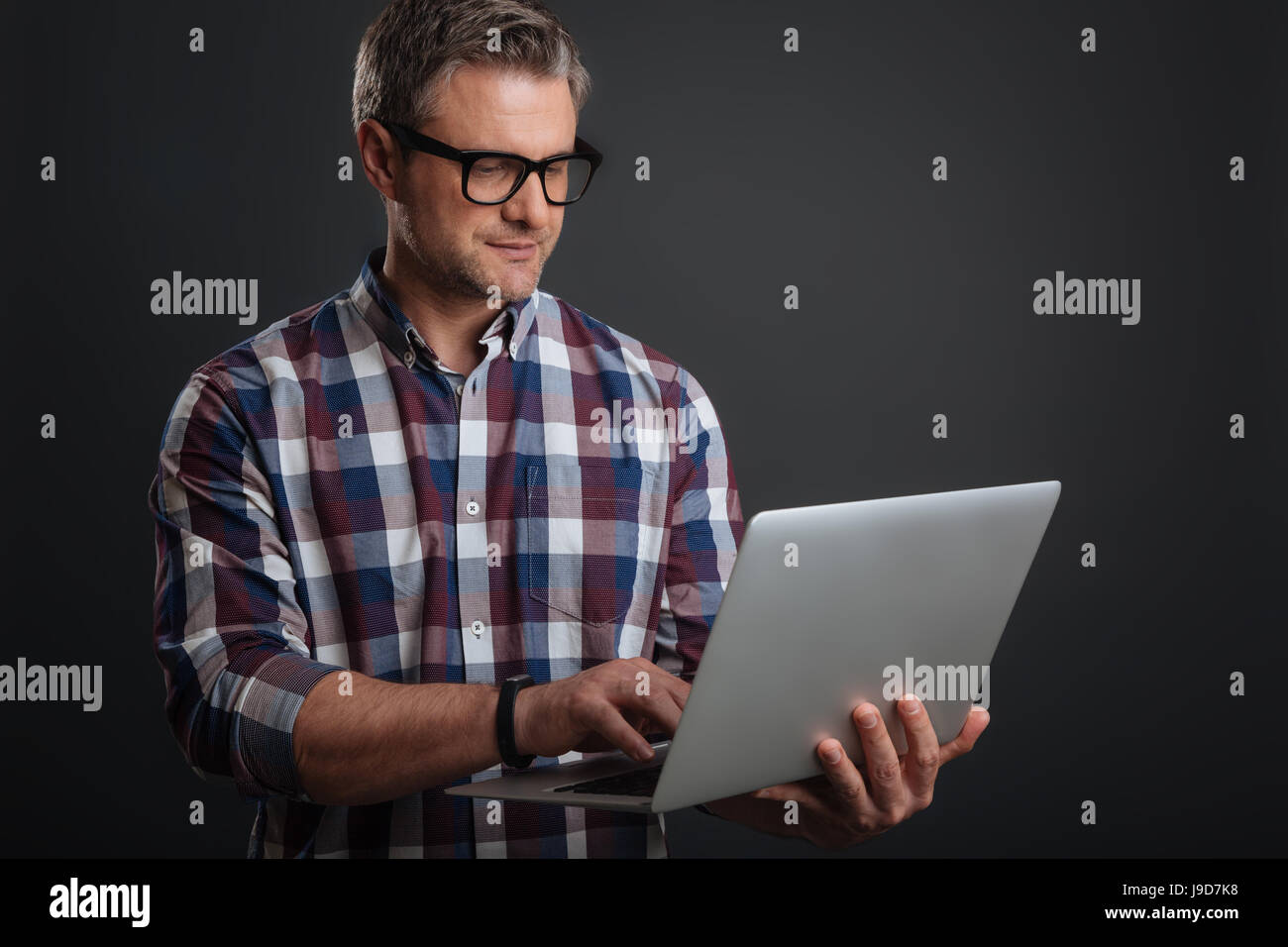 Working from anywhere. Focused motivated handsome guy writing an email ...