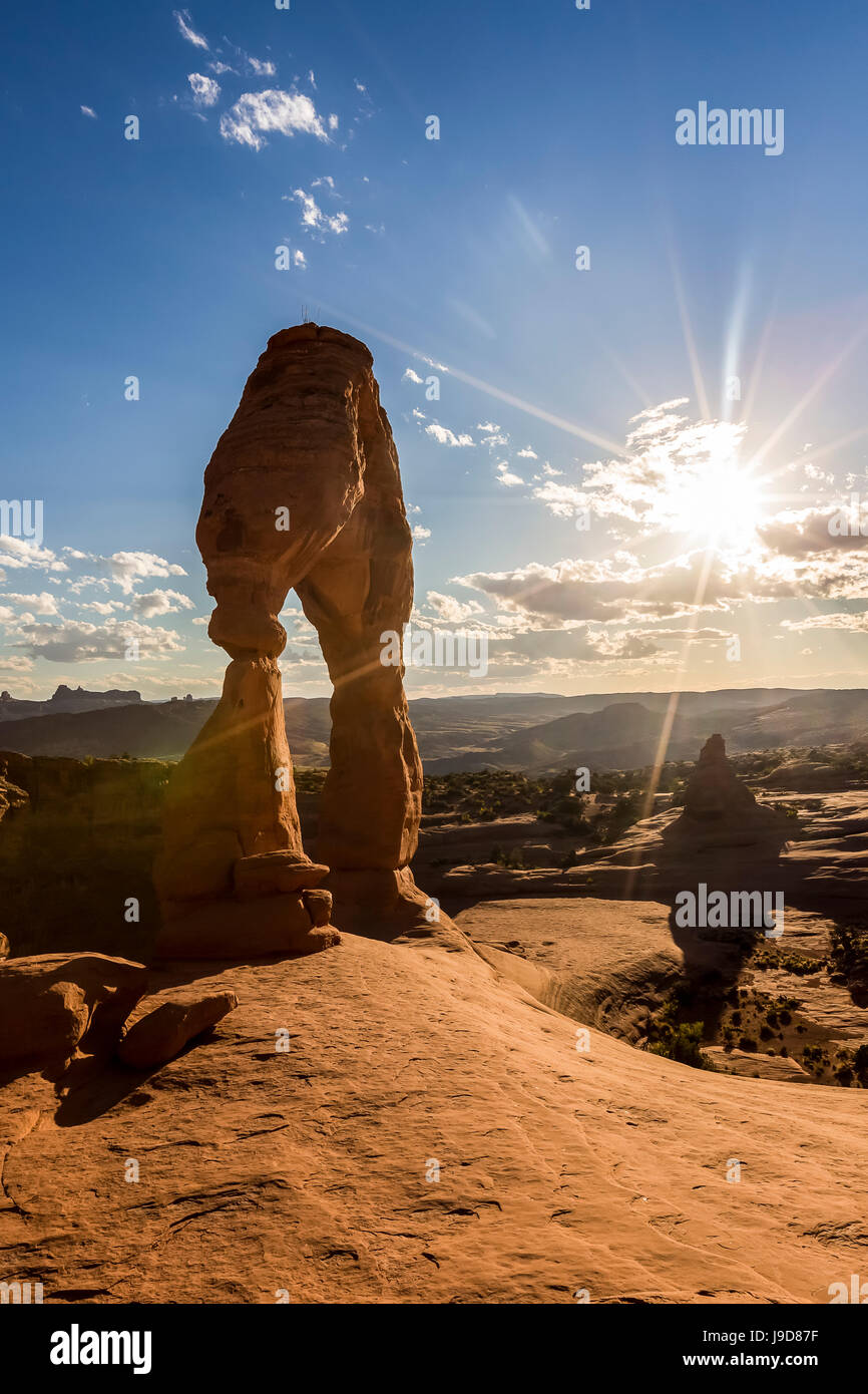 Delicate Arch with sun and clouds at golden hour, Arches National Park ...
