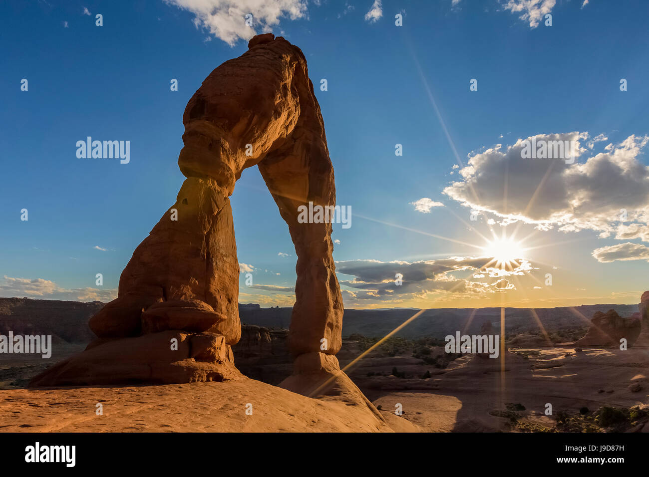 Delicate Arch with sun and clouds at golden hour, Arches National Park ...
