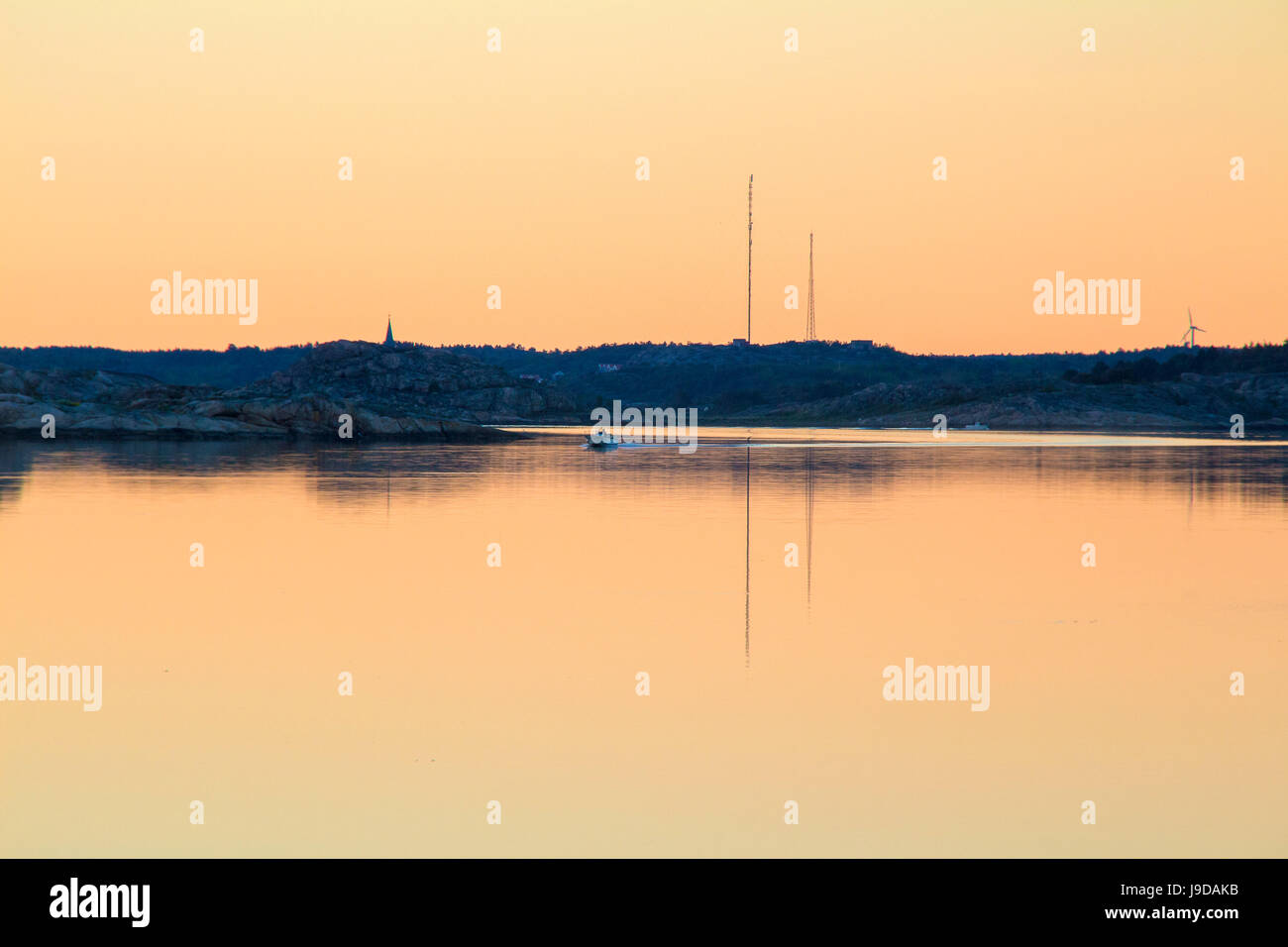 Boat driving in the sunset over mirror clear ocean Stock Photo - Alamy