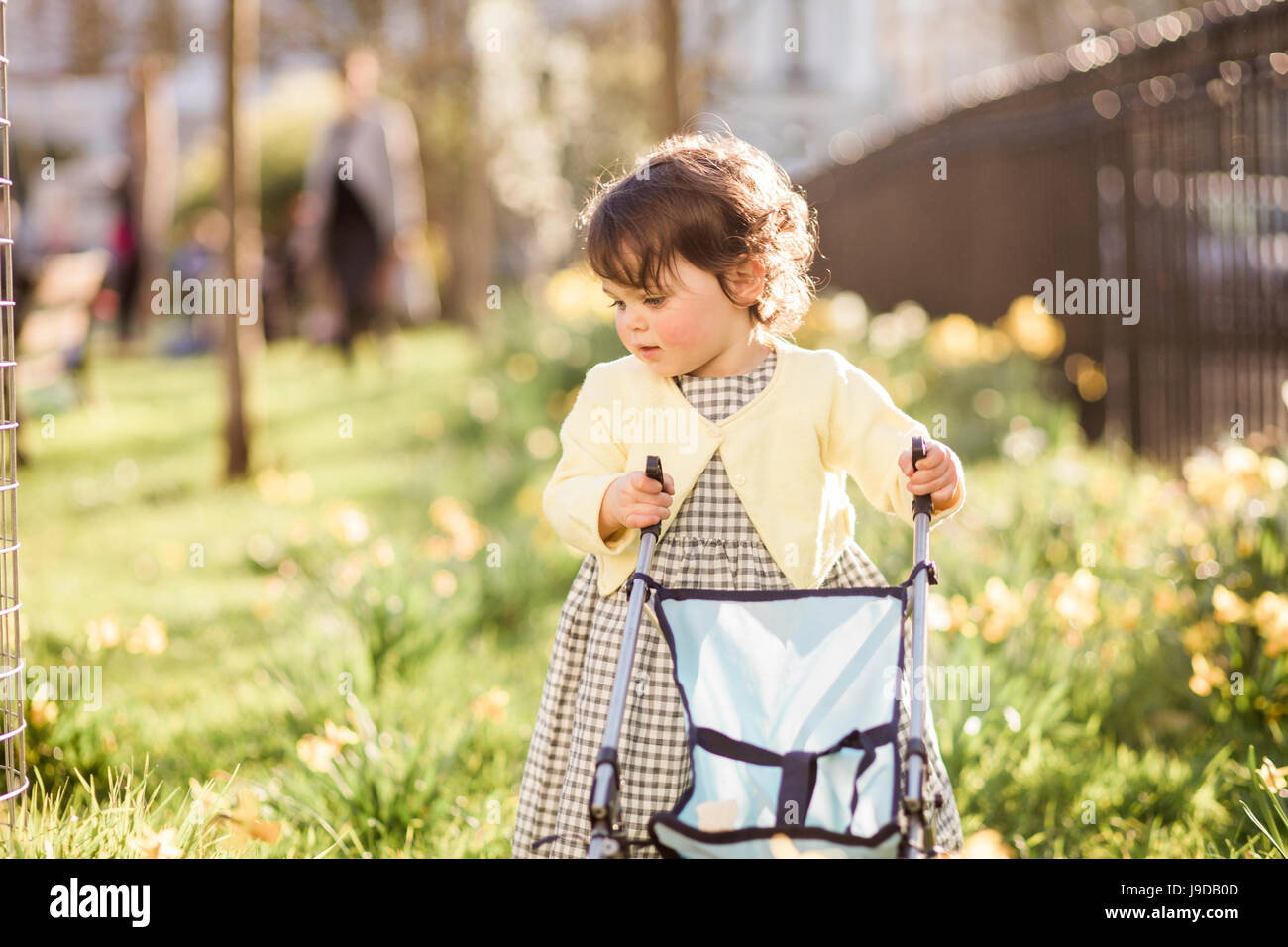 Young Girl Pushing Toy Stroller in Park Stock Photo - Alamy