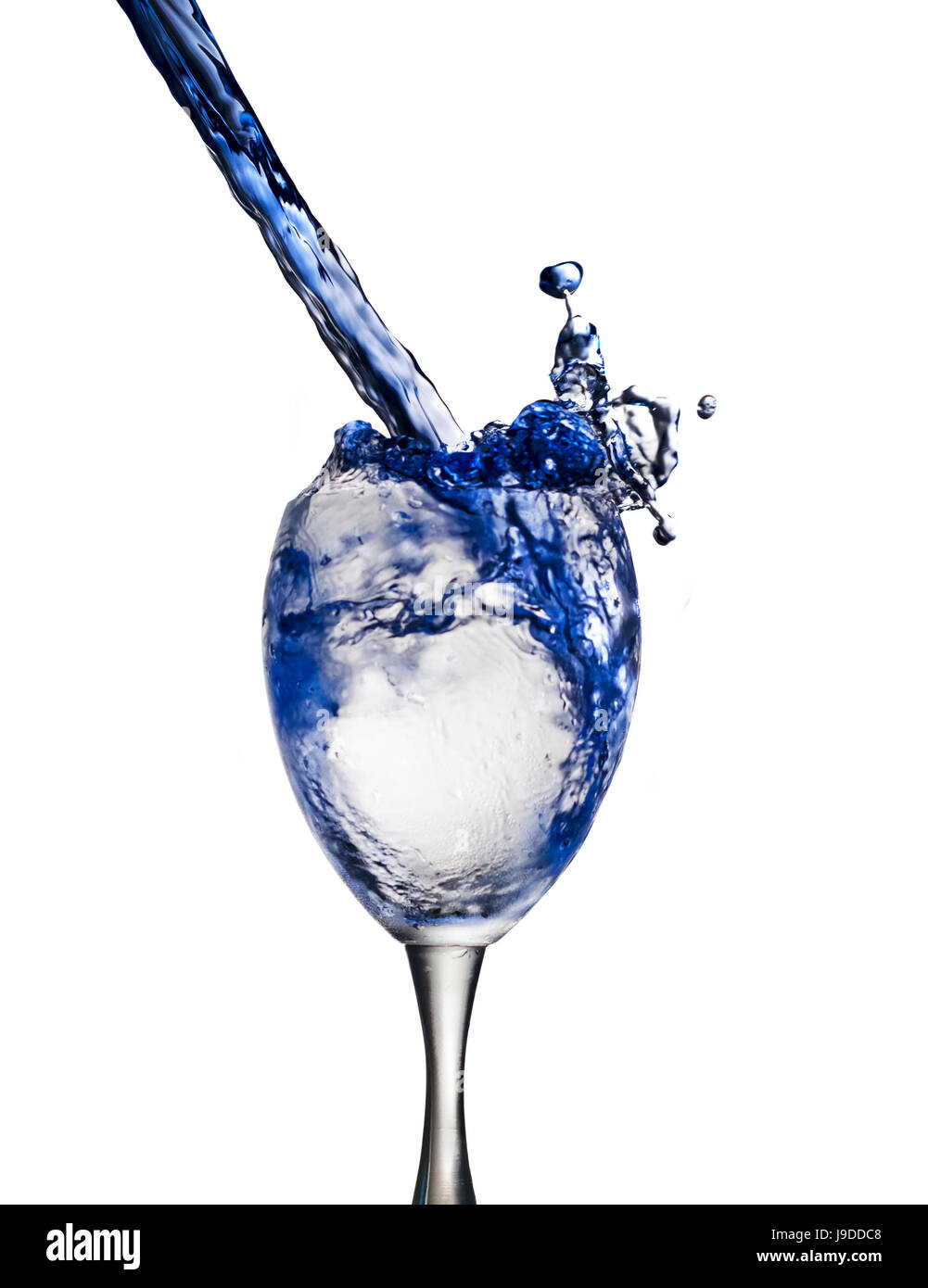 A blue drink is poured into wine glass causing a splash, isolated on ...