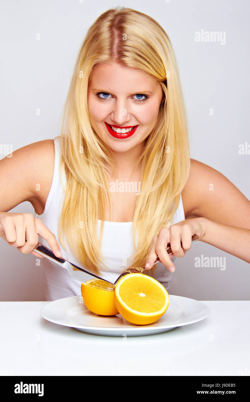 happy young woman eating fruit with silverware Stock Photo - Alamy