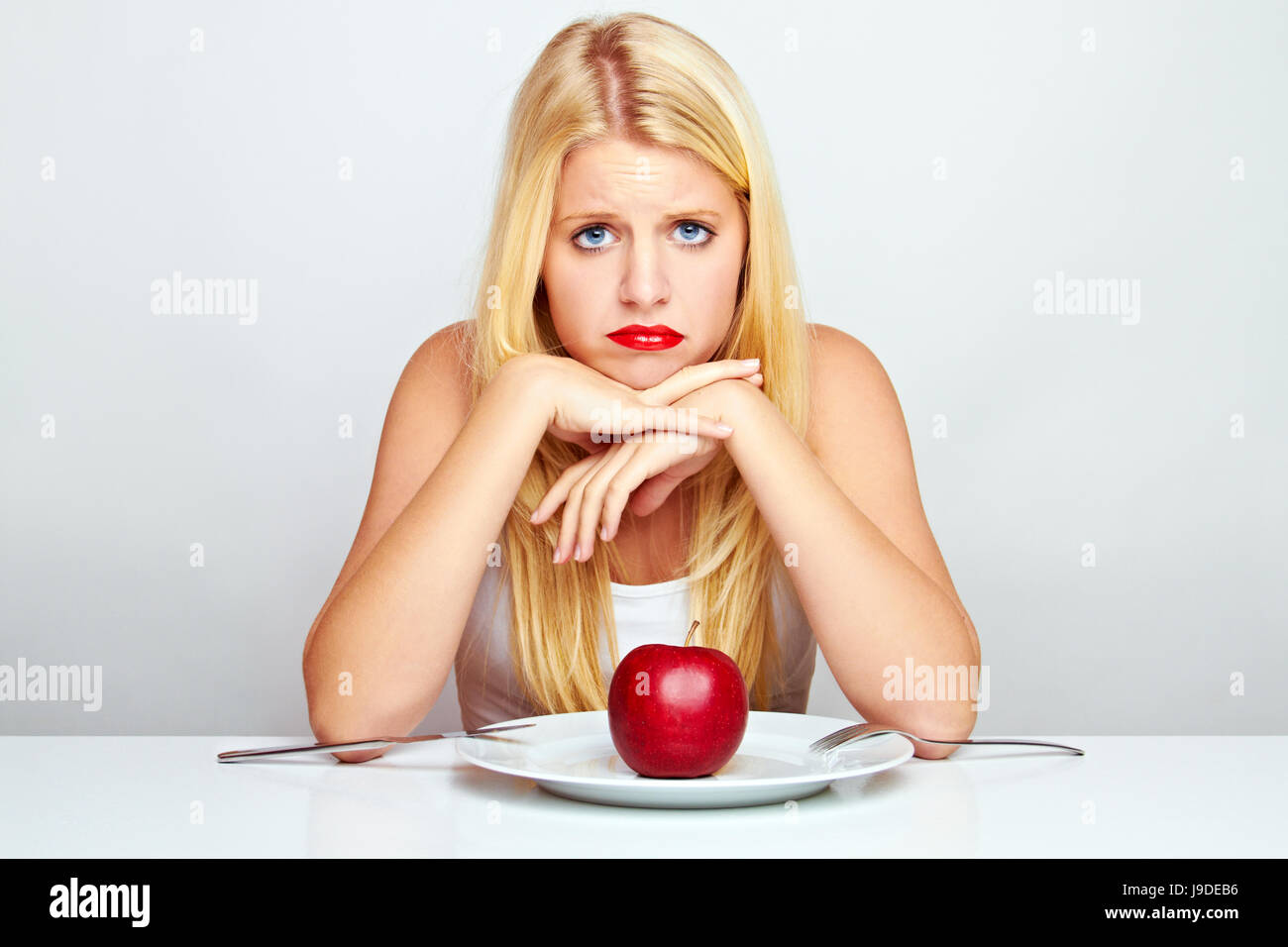 happy young woman eating fruit with silverware Stock Photo - Alamy
