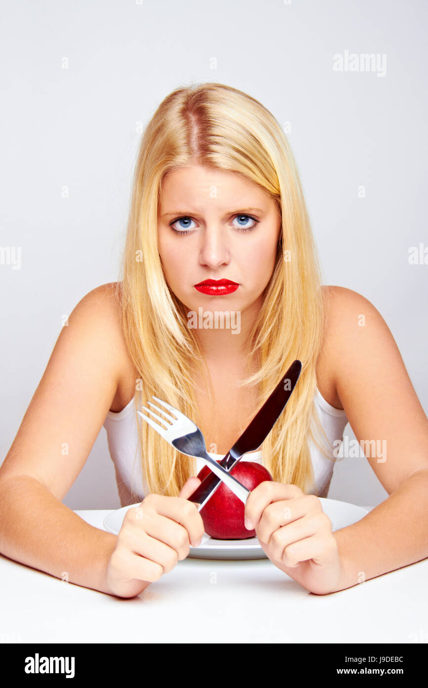 happy young woman eating fruit with silverware Stock Photo - Alamy