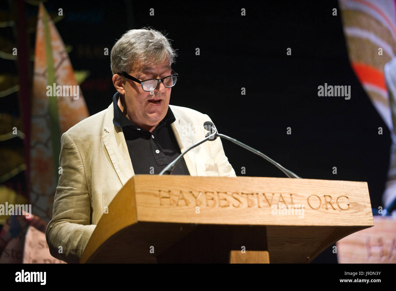 Stephen Fry reading from lectern at Letters Live event at Hay Festival ...