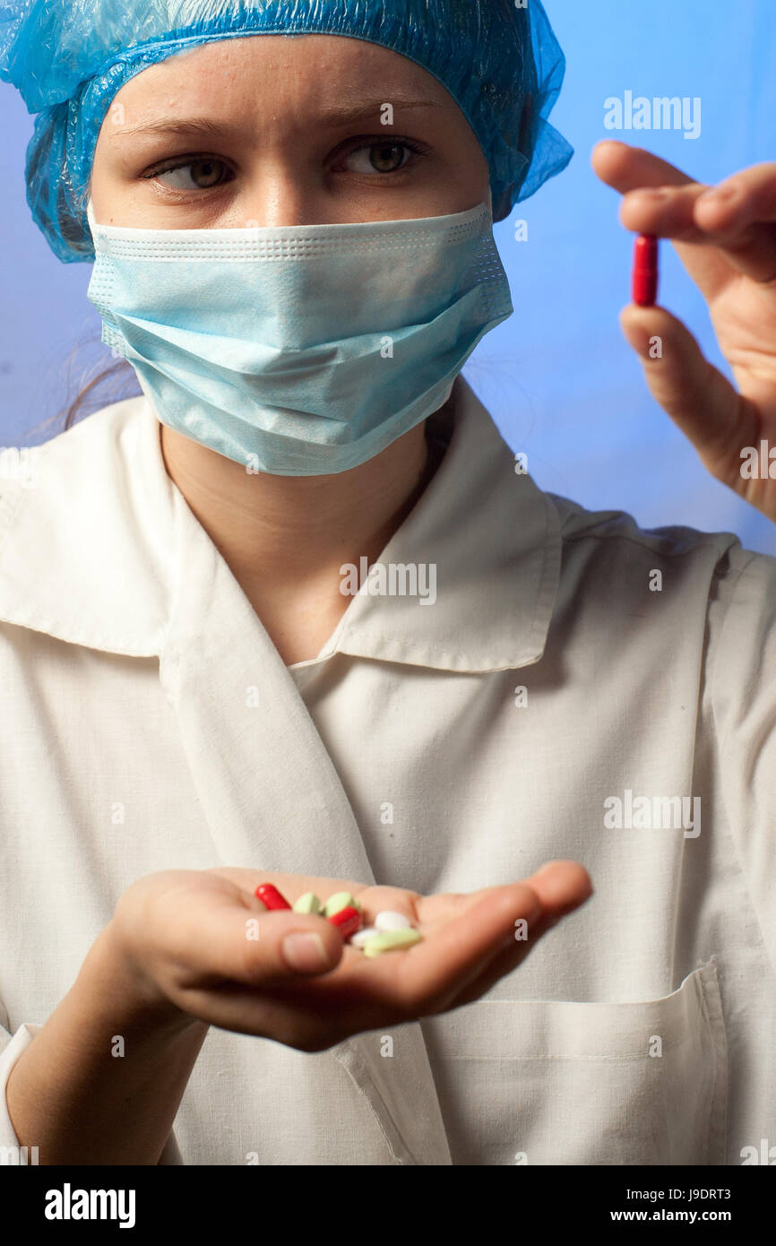 A nurse in a hospital with medication tablets in his hand for the sick ...