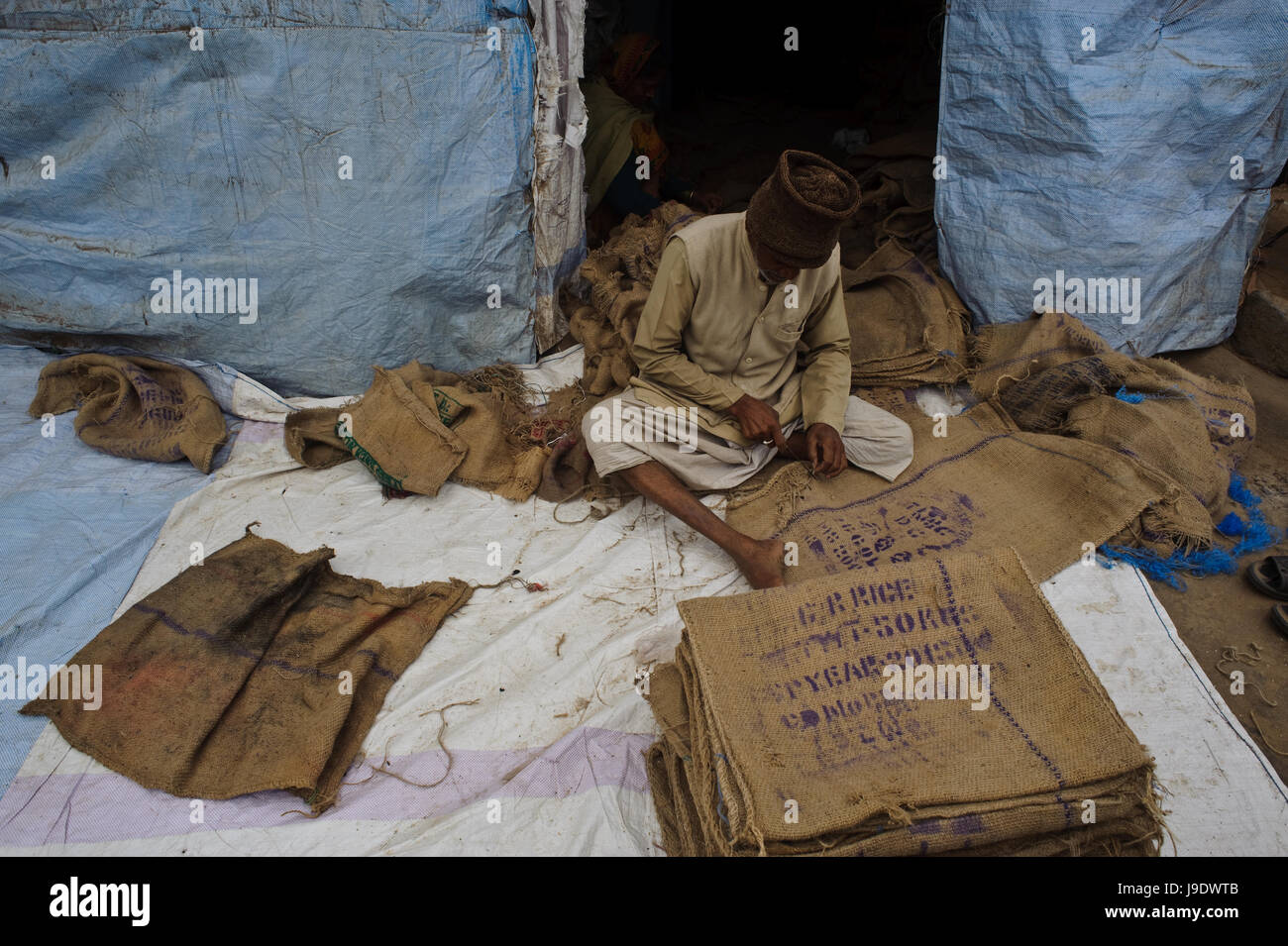 Man sewing used jute sacks ( India Stock Photo - Alamy