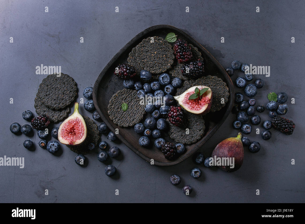 Variety of berries and figs with black crackers Stock Photo - Alamy