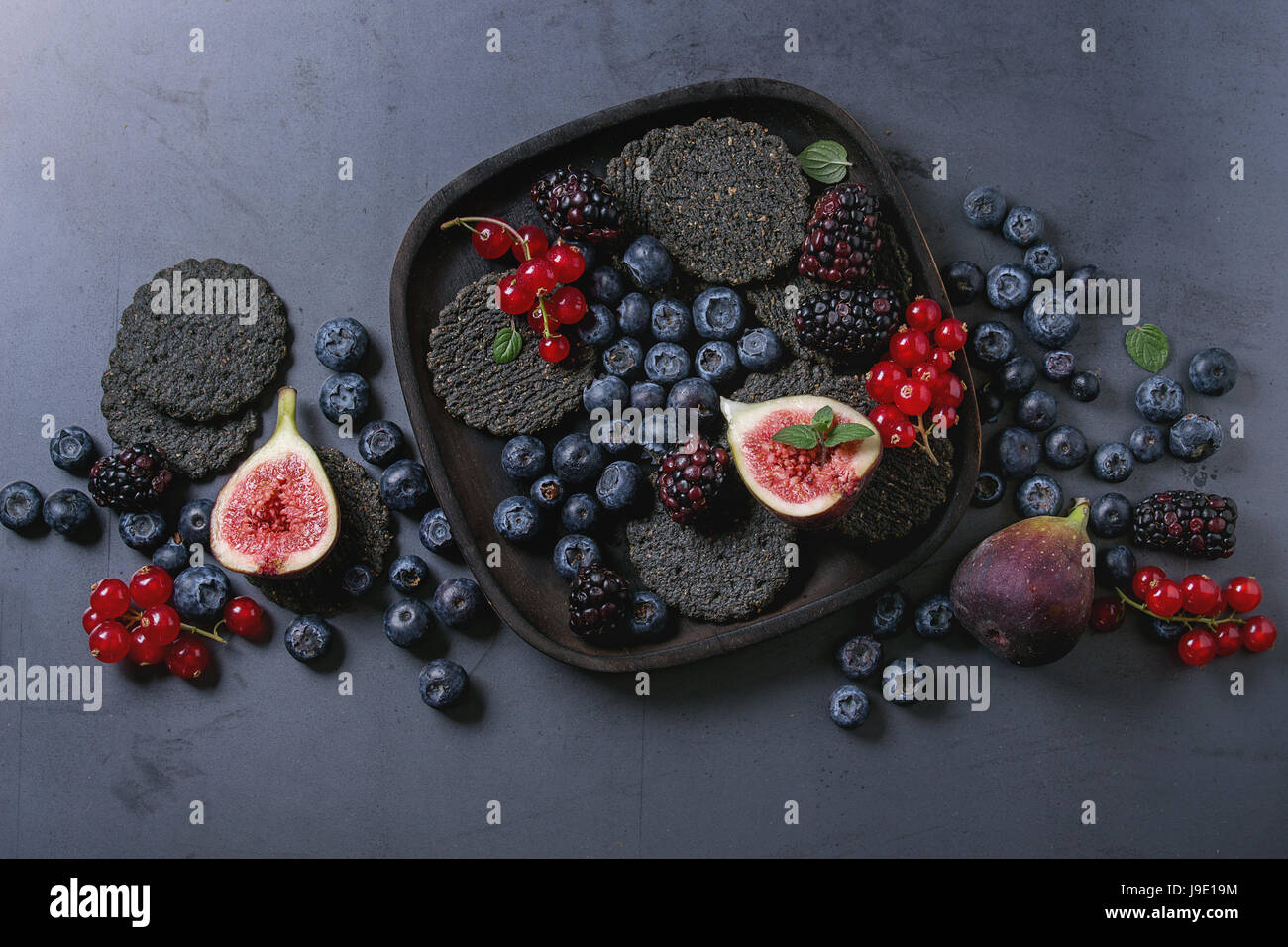 Variety of berries and figs with black crackers Stock Photo - Alamy