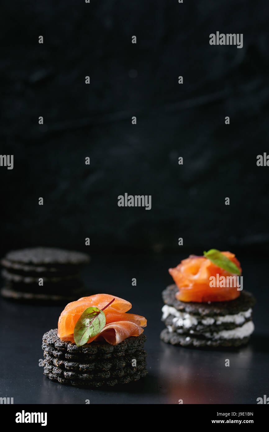 Black crackers with salmon and berries Stock Photo - Alamy