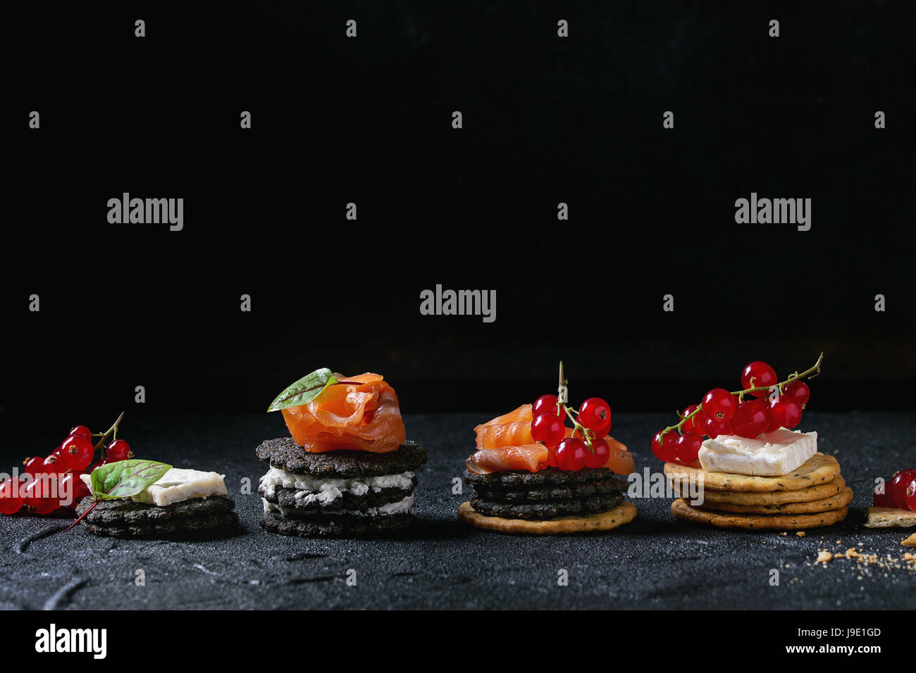 Black crackers with salmon and berries Stock Photo - Alamy