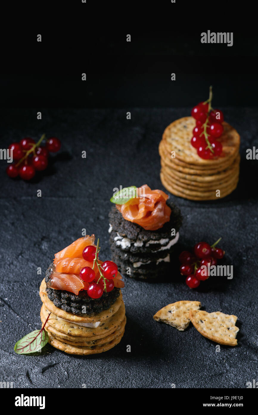 Black crackers with salmon and berries Stock Photo - Alamy