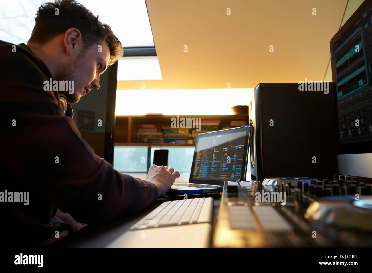 Young Man Composing Music on Laptop Computer in Bedroom Stock Photo - Alamy