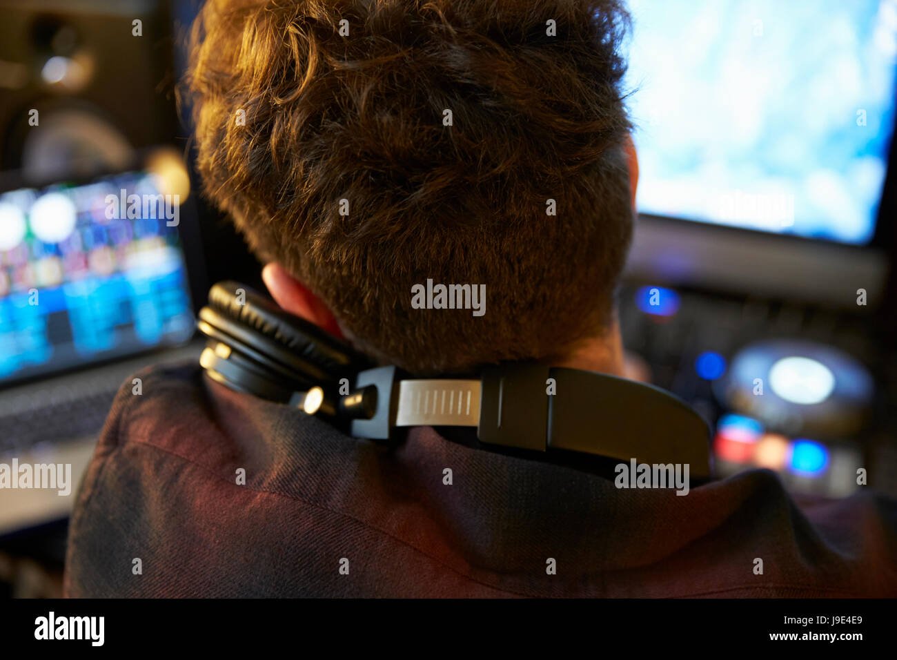 Young Man Mixing Music using Headphones Stock Photo - Alamy