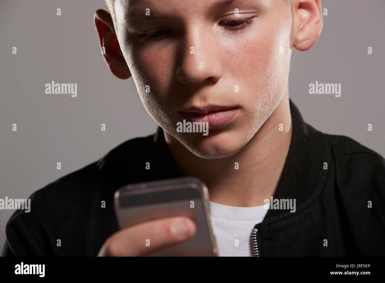 White teenage boy using mobile phone, close up, horizontal Stock Photo ...