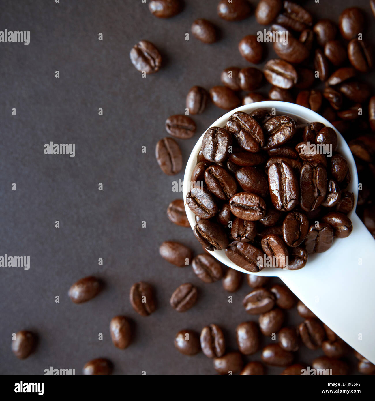 A small scoop of roasted coffee beans Stock Photo - Alamy