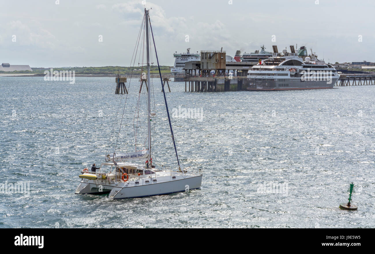 A catamaran passes the docked cruise ship and ferries at Holyhead on ...