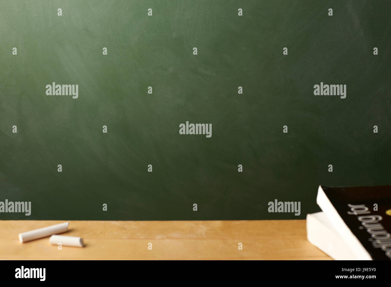 School text book and chalk on desk in front of chalkboard Stock Photo ...