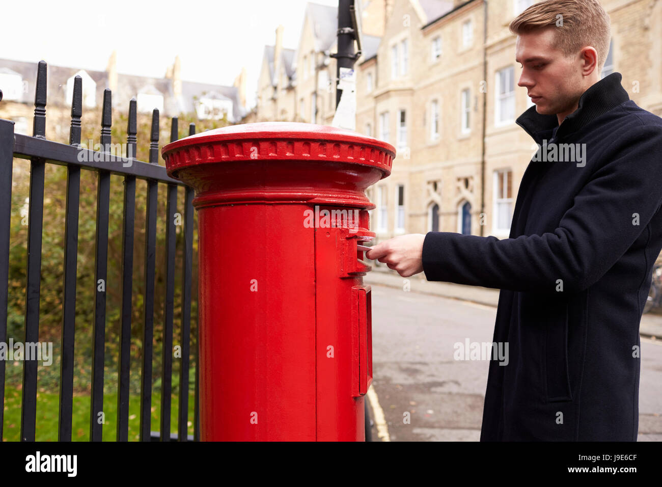 Man Posting Letter In Red British Postbox Stock Photo - Alamy