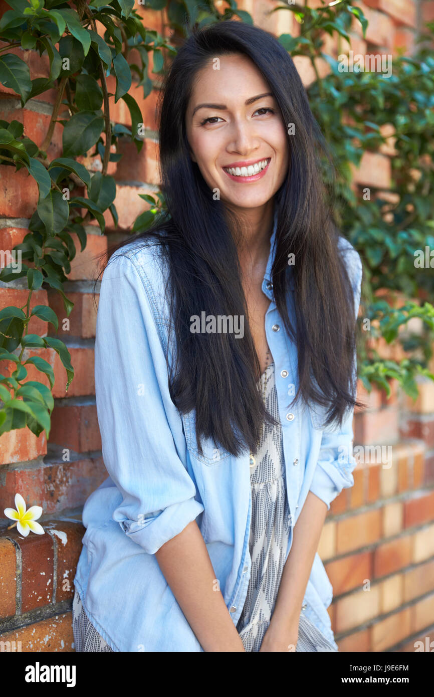 Mixed race Asian woman looks to camera, three quarter length Stock ...