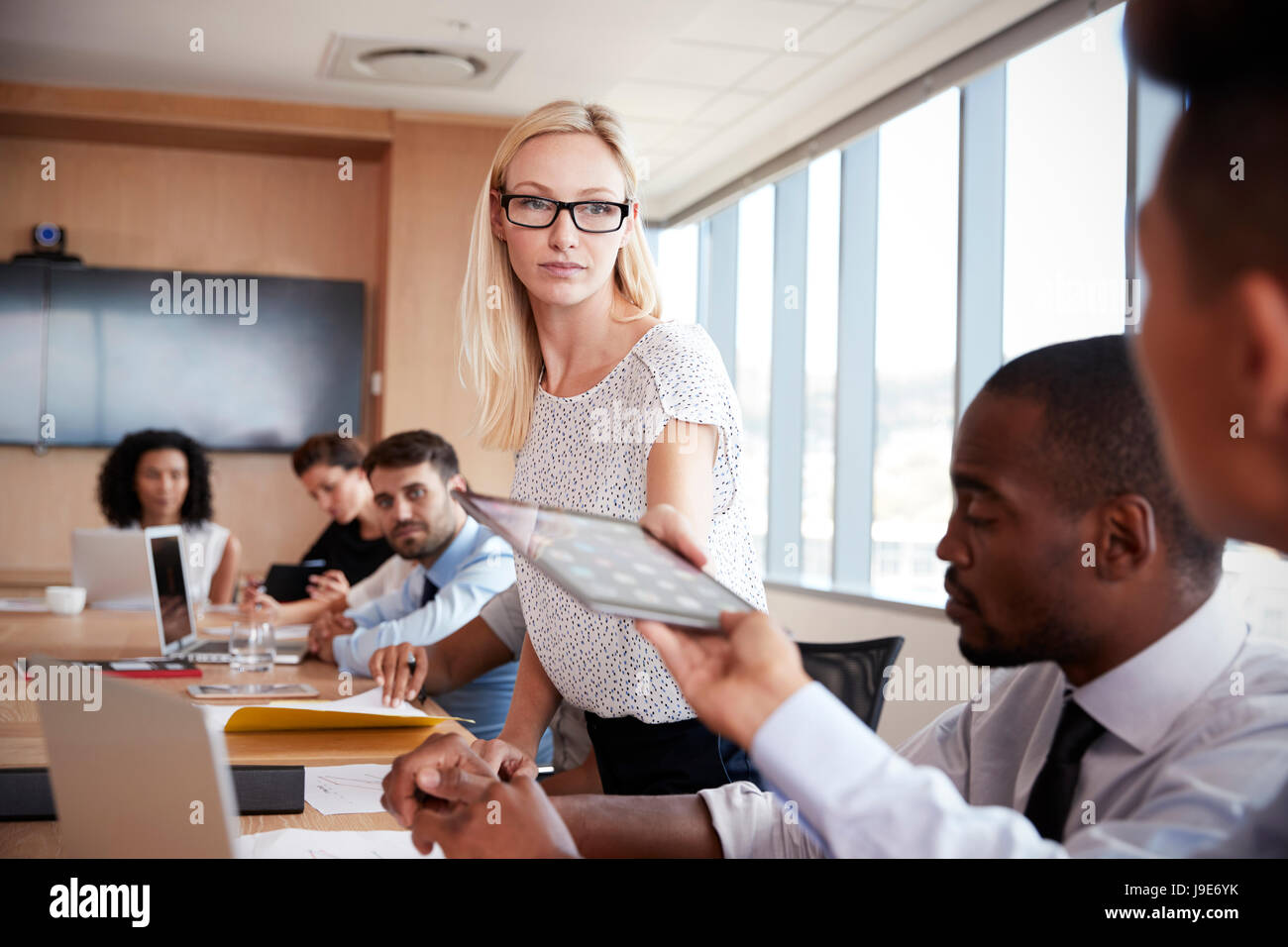 Businesswoman Stands To Address Meeting Around Board Table Stock Photo ...