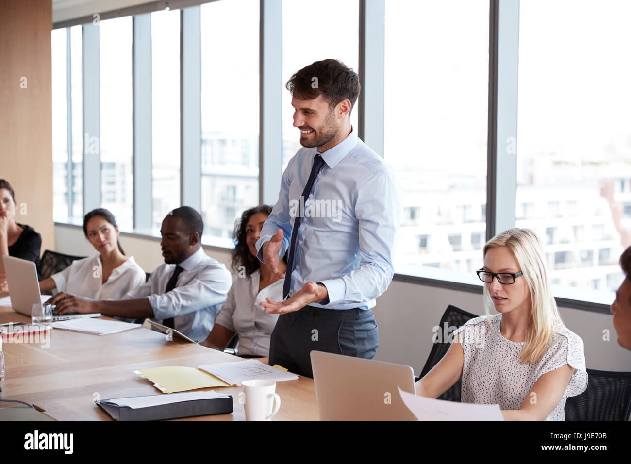 Businessman Stands To Address Meeting Around Board Table Stock Photo ...
